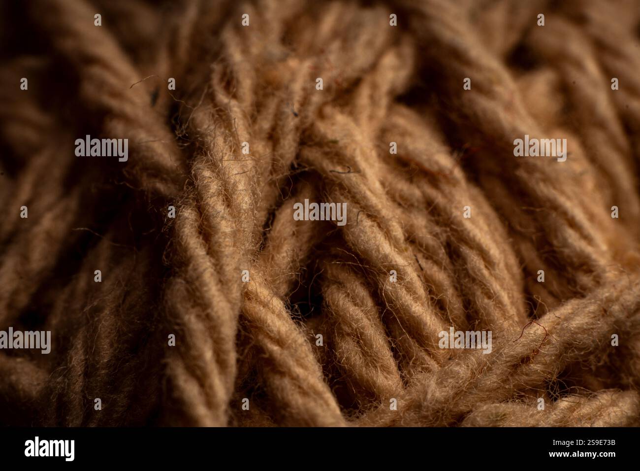Creative weaving of natural brown yarn threads on textured fabric ...