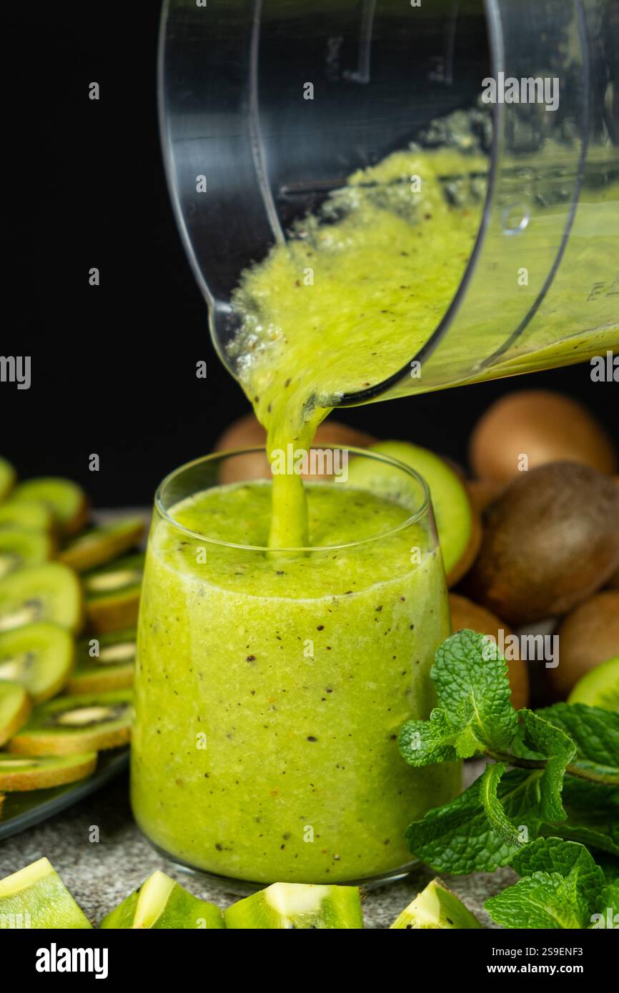 Fresh green kiwi smoothie pour from blender bowl into glass Stock Photo ...