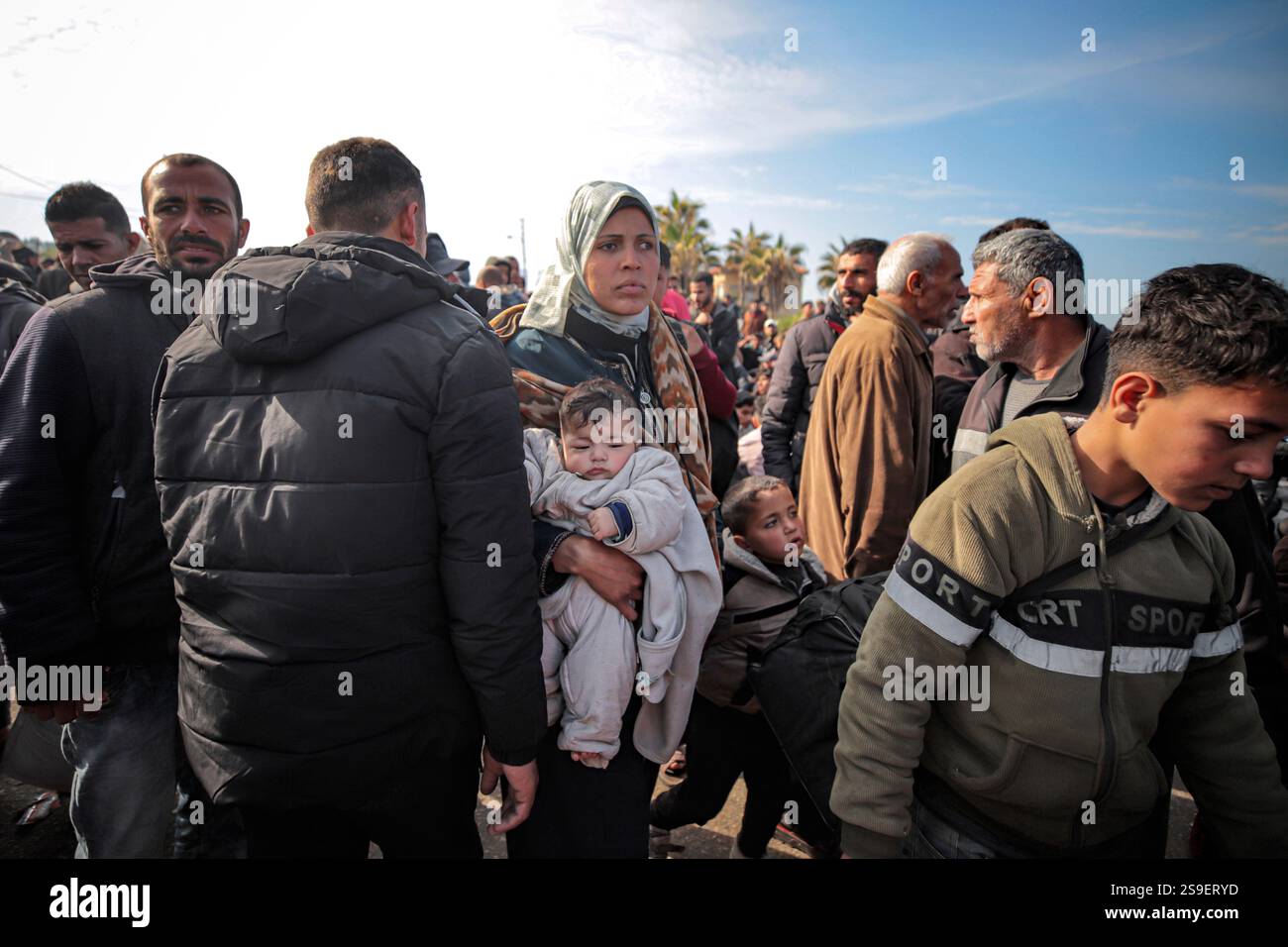Displaced Palestinians gather with their belongings near a roadblock on ...
