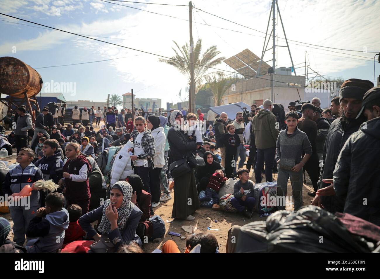 Displaced Palestinians gather with their belongings near a roadblock on ...
