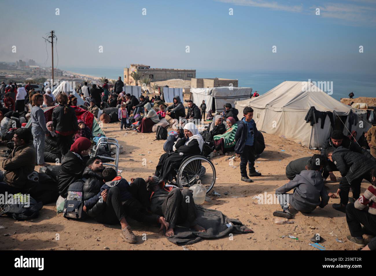 Displaced Palestinians gather with their belongings near a roadblock on ...