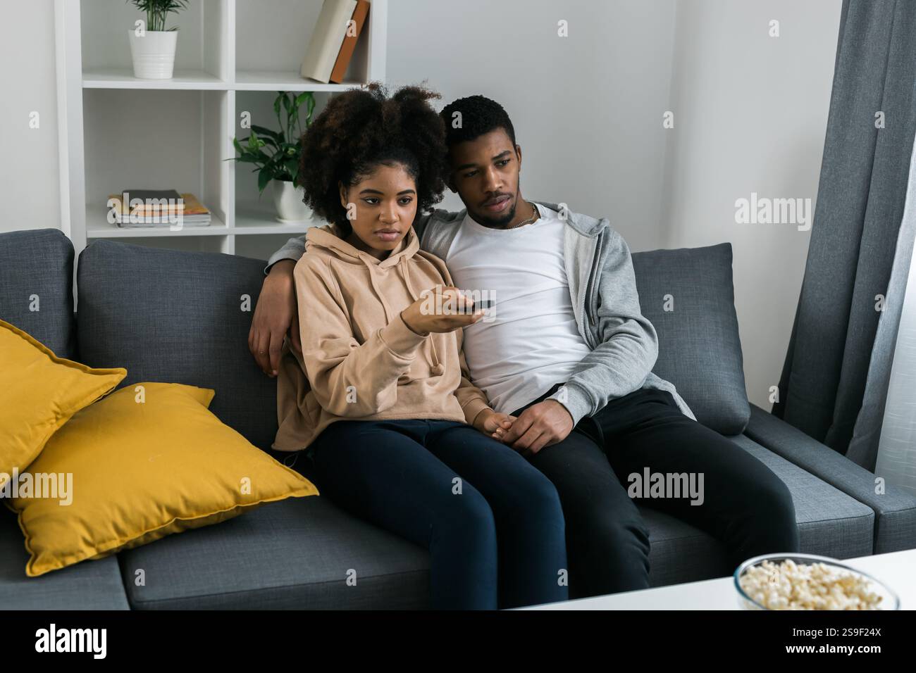 African American couple wife husband watching movie. Family pastime and leisure, watch ...