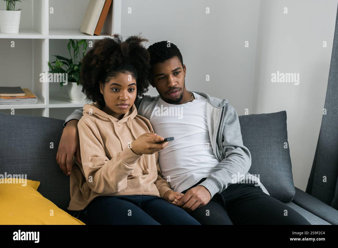 African American couple wife husband watching movie. Family pastime and leisure, watch ...