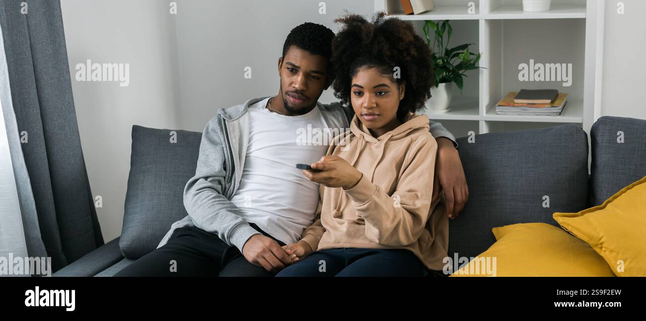 African american couple wife husband watching movie. Family pastime and leisure, watch ...