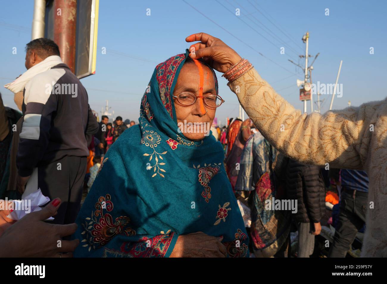A Hindu devotee has vermilion applied to her nose and forehead after ...