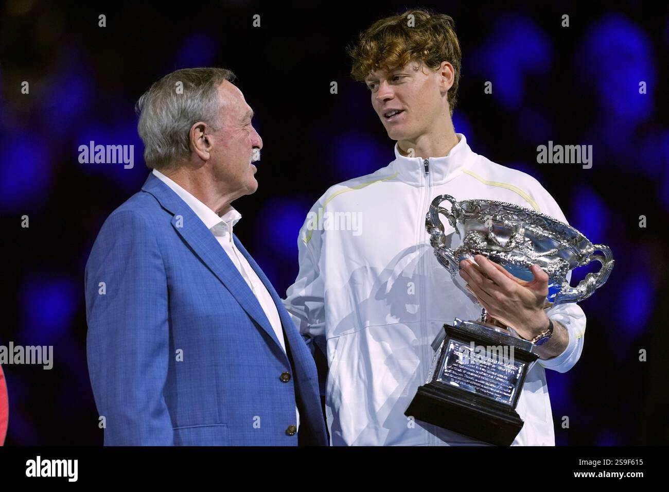 Jannik Sinner, right, of Italy holds the Norman Brookes Challenge Cup as he talks to John ...