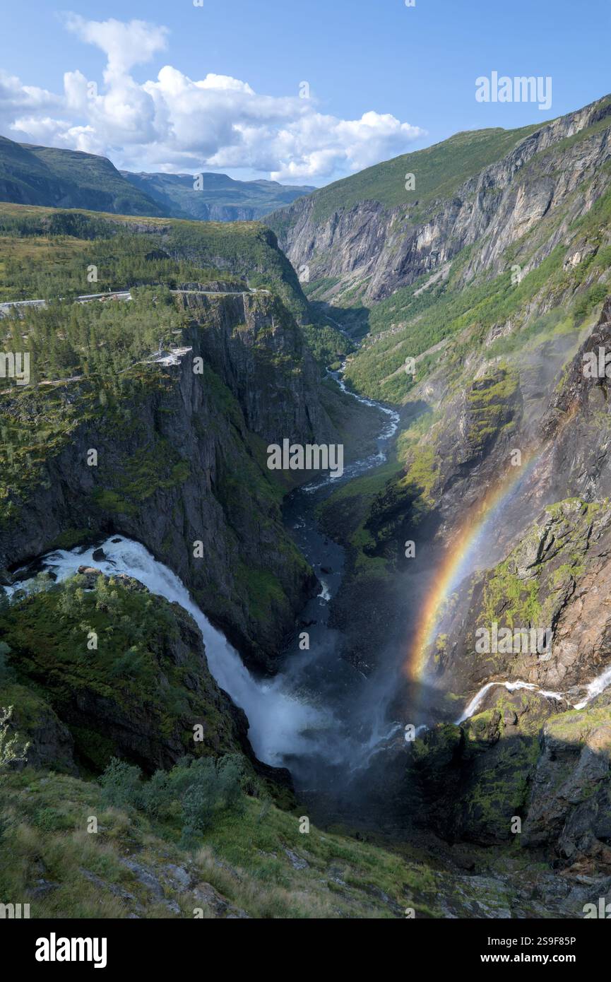 Waterfall cascading down a steep canyon, surrounded by lush green ...