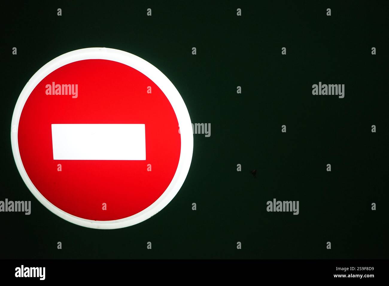 A bright red circular sign displays a horizontal white bar, indicating ...