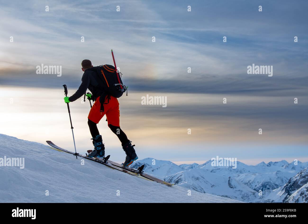 Colorful silhouette of skier standing on slope, Kasprowy Wierch Peak in ...