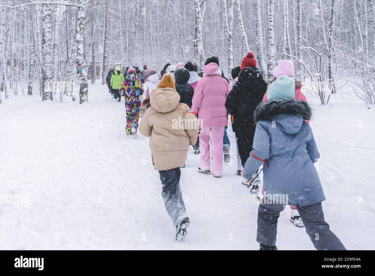 A cheerful group of children in colorful winter clothing walking ...