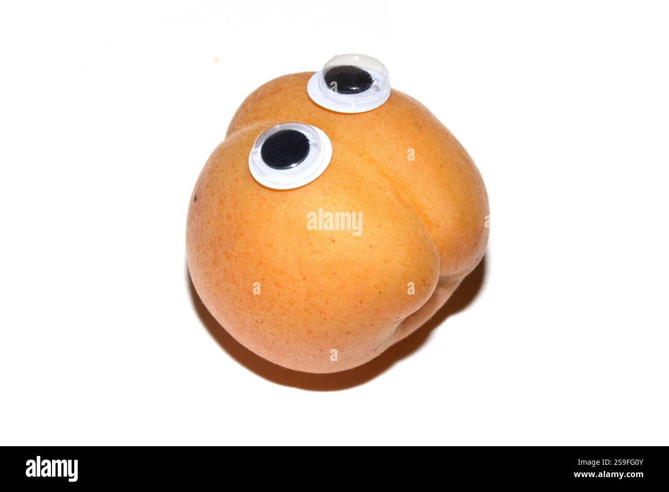 Close up of a fresh apricot fruit with Boggle Eyes Silly Stock Photo ...
