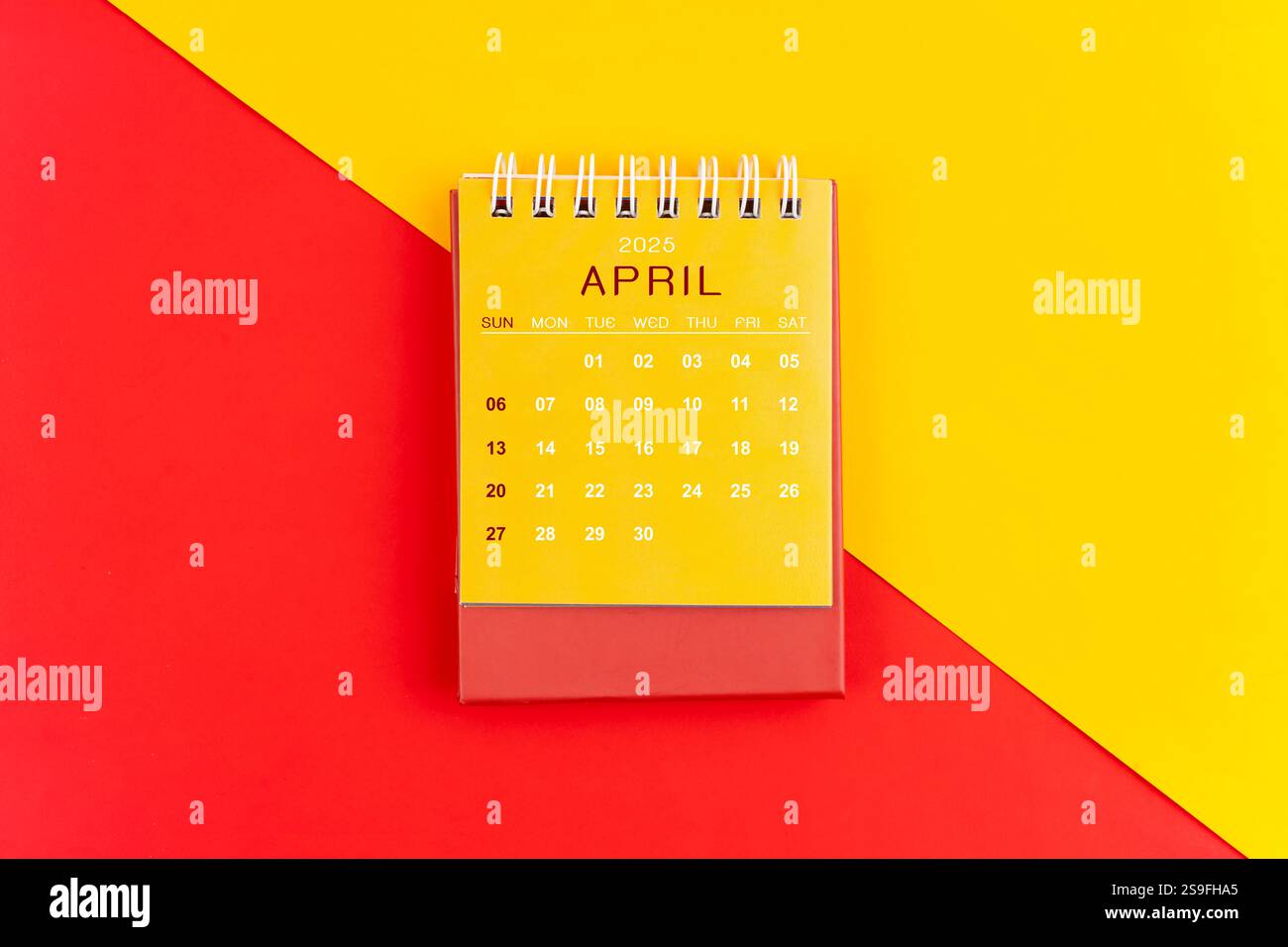 April 2025 desk calendar on red and yellow color background Stock Photo ...