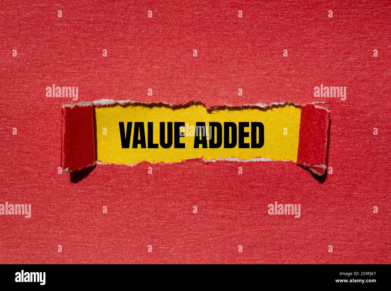 Value added message written on ripped torn red paper with yellow background. Conceptual value ...