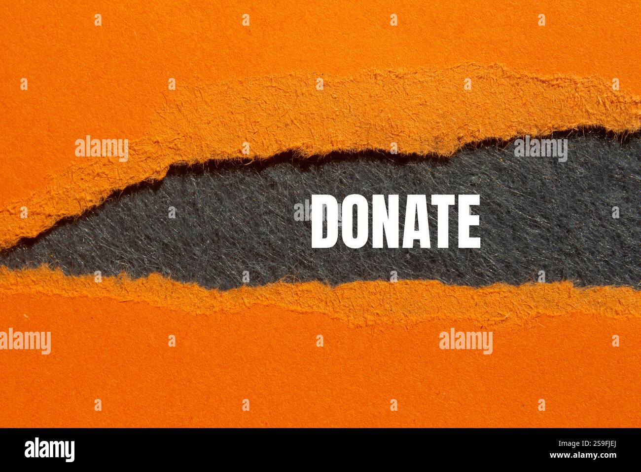 Donate message written on ripped torn orange paper with gray background ...