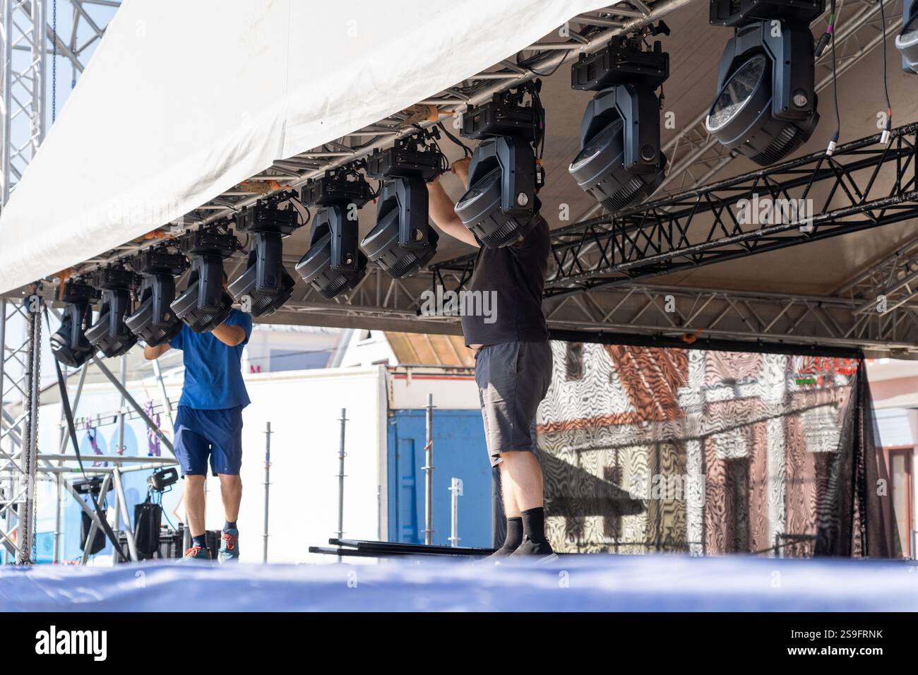 Installation of lighting equipment on a mobile concert stage. A worker ...