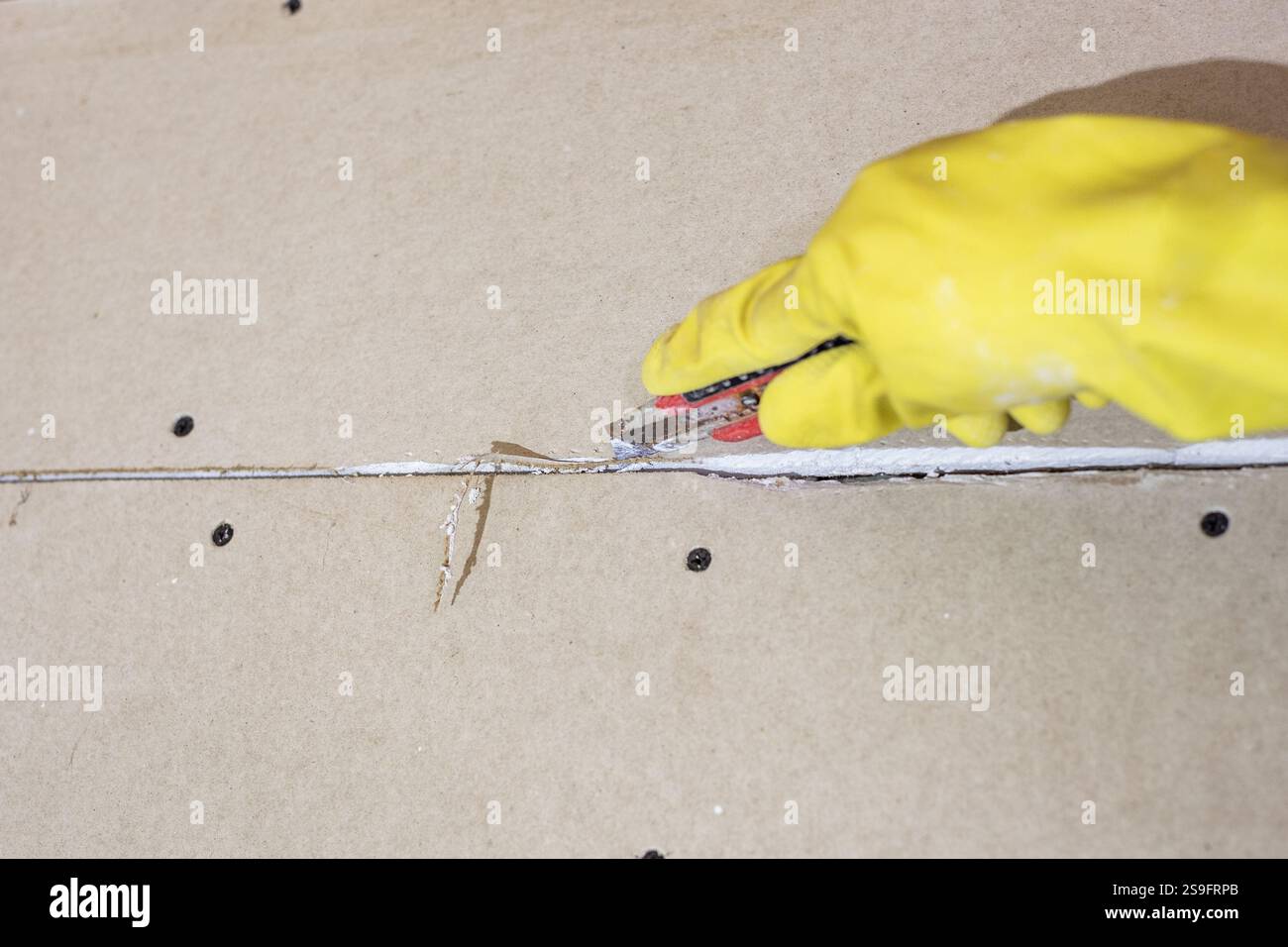 Preparing drywall for putty and plaster. The craftsman cuts the edge of ...
