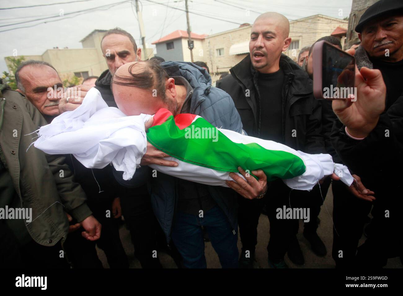 Mourners surround the flag-draped body of two-year old Laila al-Khatib ...
