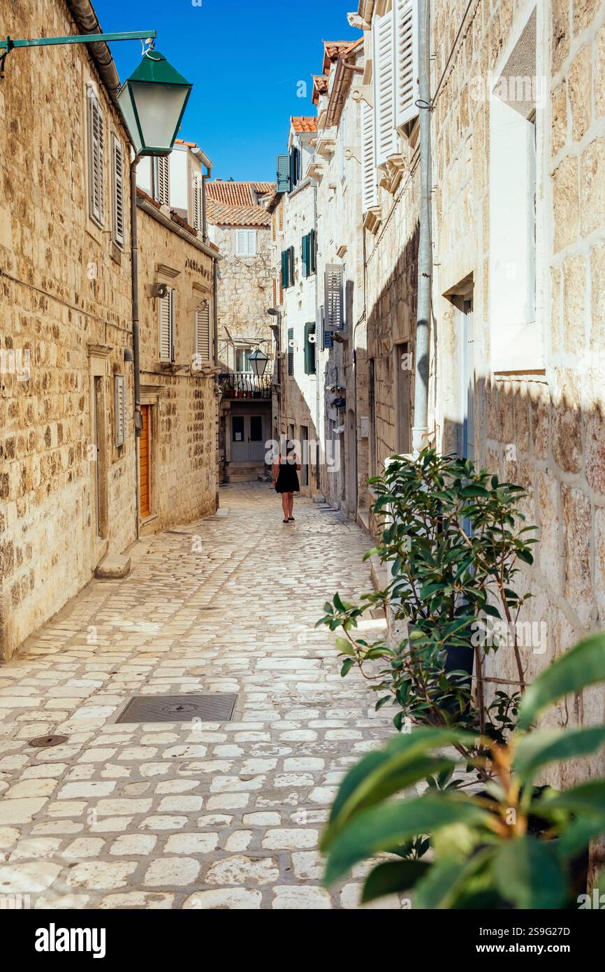Female tourist walking along cobbled street & old buildings of Old Town ...