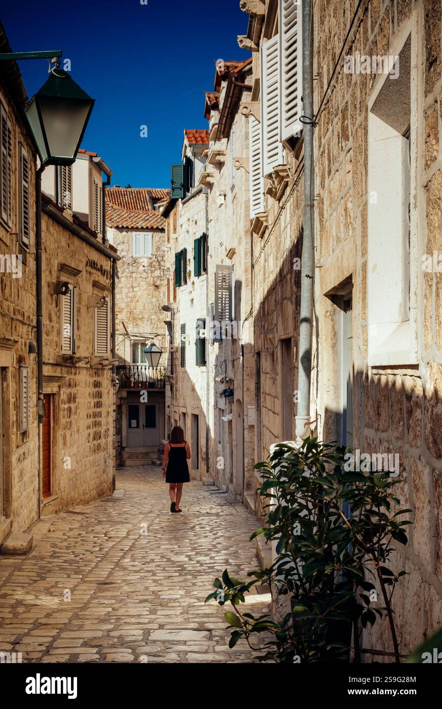 Female tourist walking along cobbled street & old buildings of Old Town ...