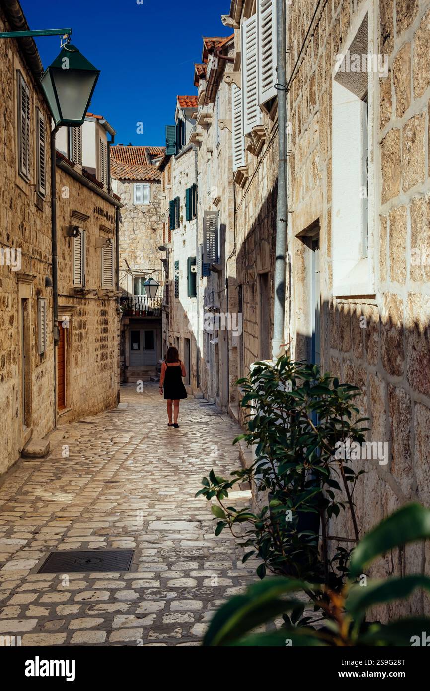 Female tourist walking along cobbled street & old buildings of Old Town ...