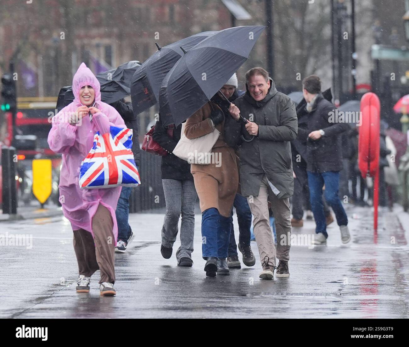 People walking in the wind and rain on Westminster bridge, in London ...