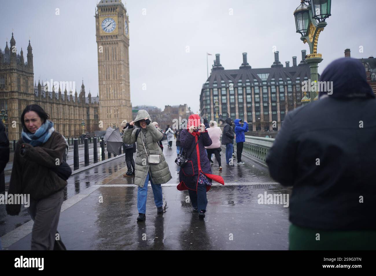 People walking in the wind and rain on Westminster bridge, in London ...