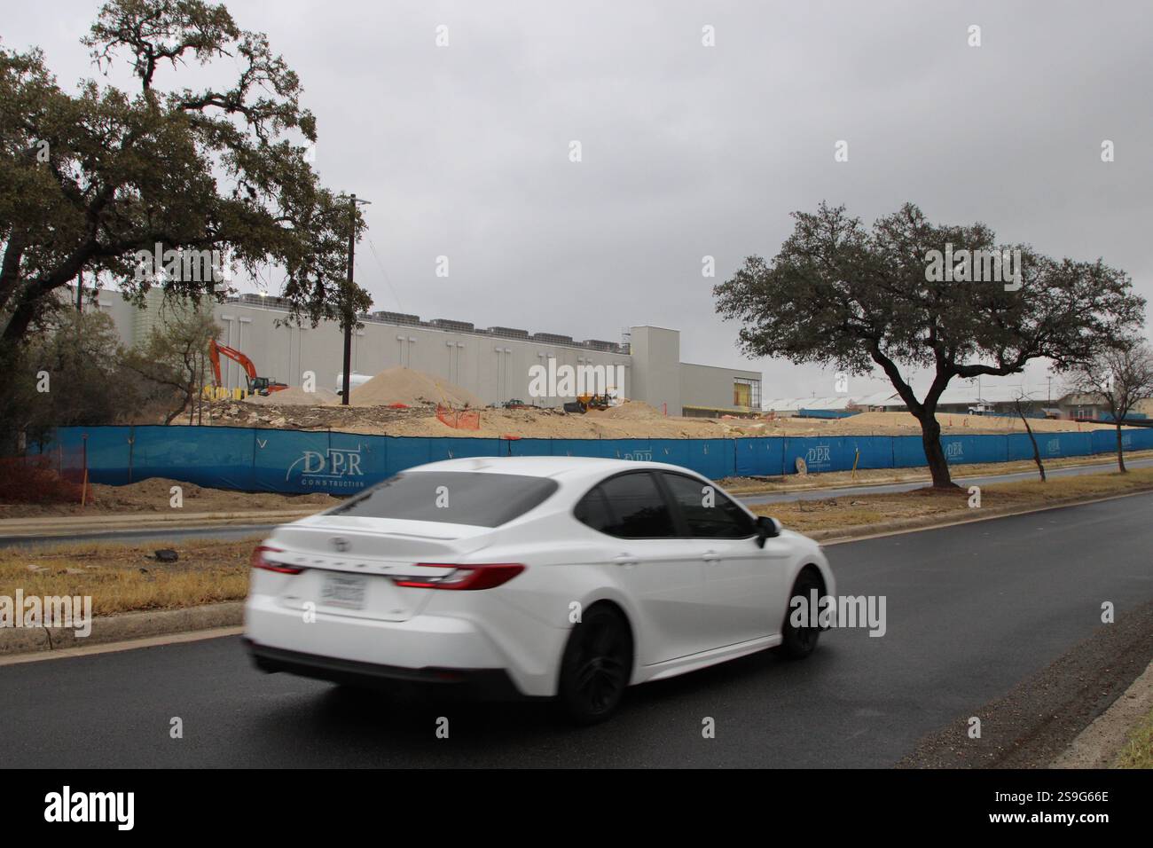 A white car passes by the construction site of a massive hyperscale ...
