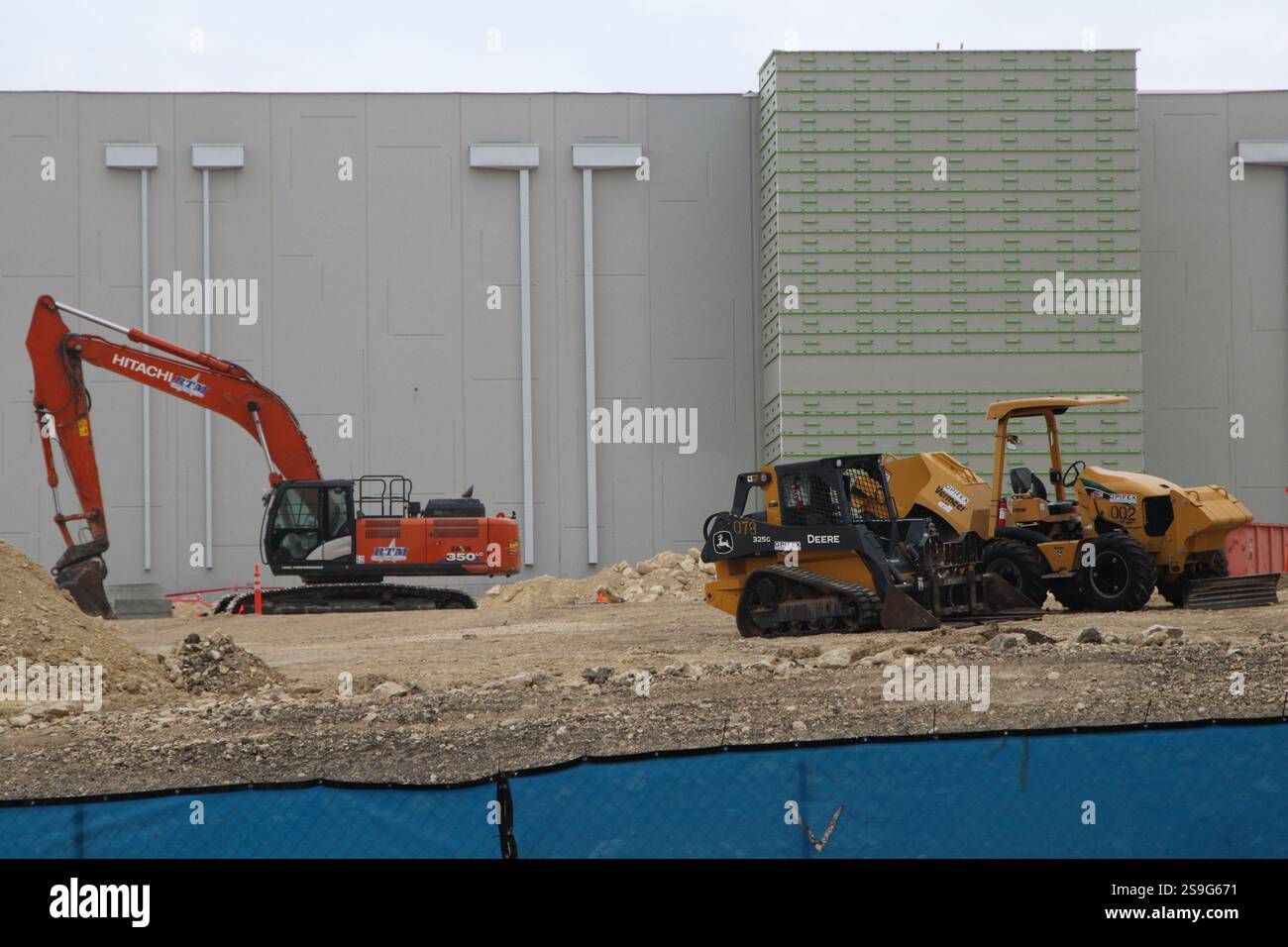 Construction equipment sits idle within the construction site of a ...