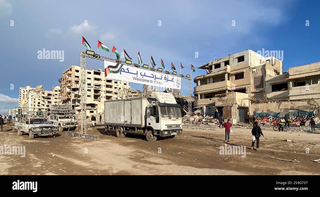 People gather by a banner welcoming people near the rubble of a ...