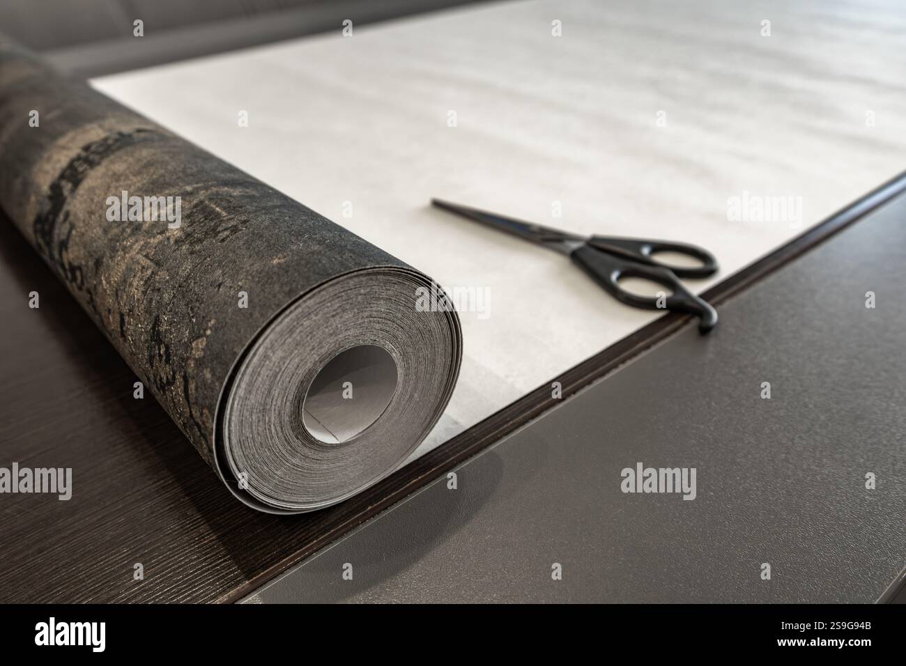 Cutting wallpaper before sticking it to the wall, scissors, measuring ...