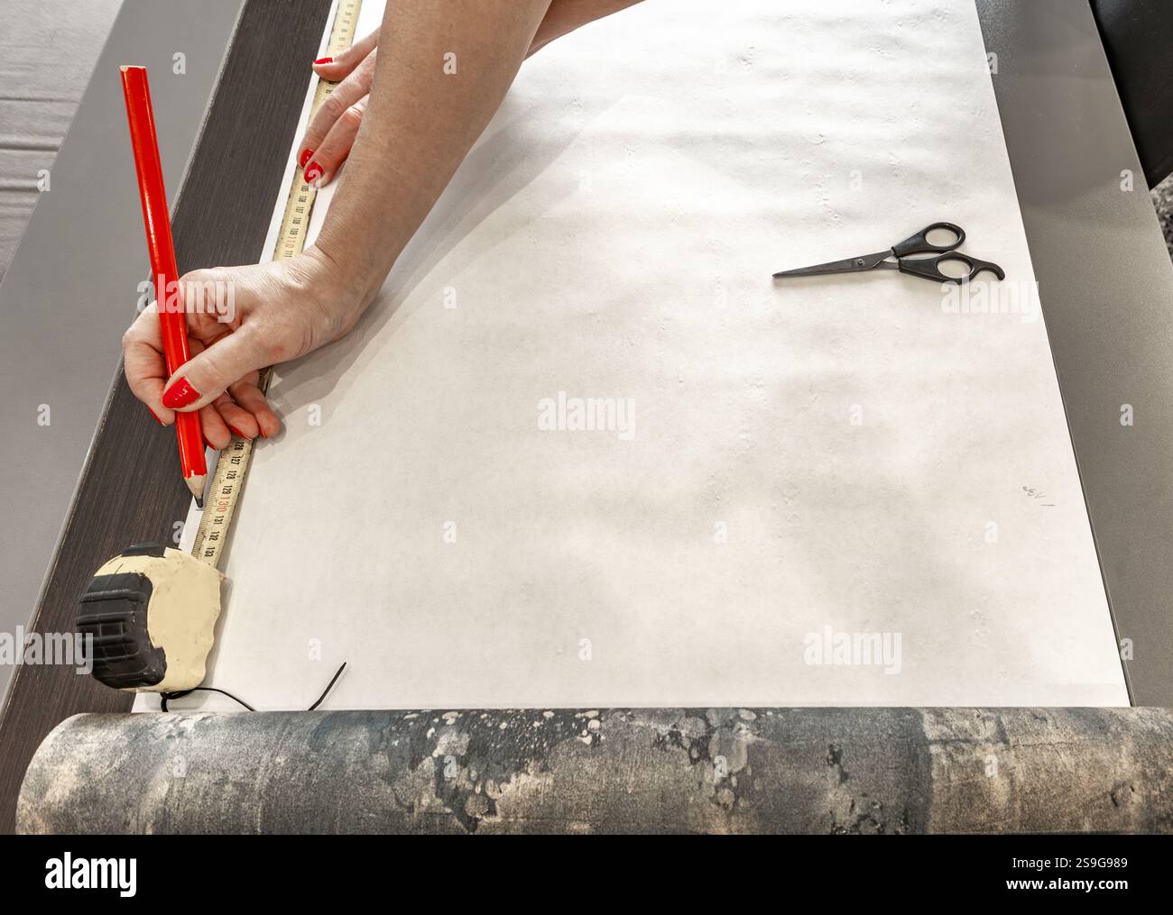 Cutting wallpaper before sticking it to the wall, scissors, measuring ...