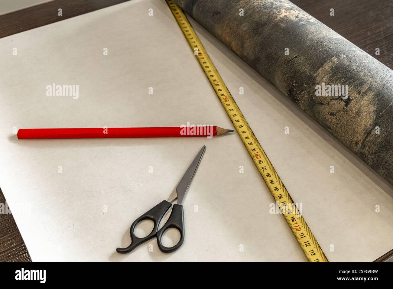 Cutting wallpaper before sticking it to the wall, scissors, measuring ...
