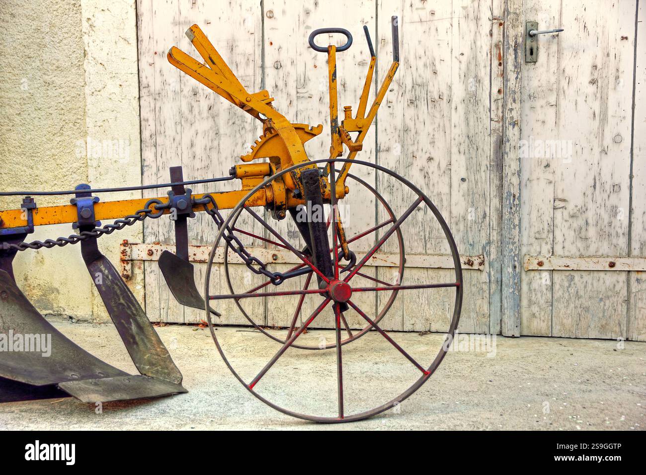 A vintage farm mechanized plow with a long pole for a hitch against the ...
