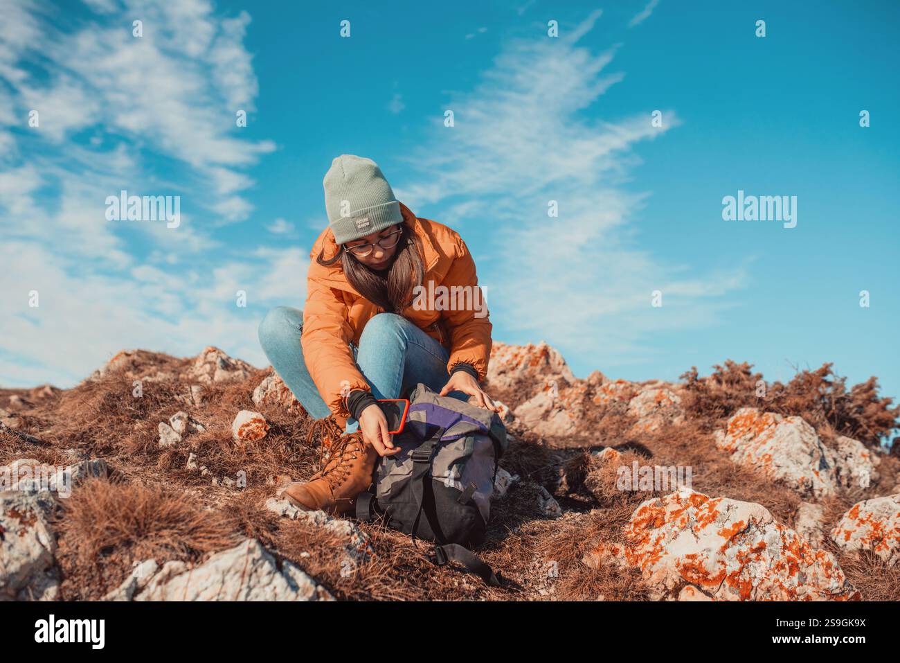 Cheering woman backpacker enjoy the view on sunrise mountain top cliff ...