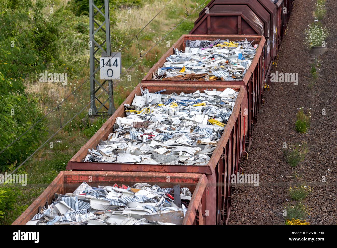 Above view of railway cargo train wagon filled by old rusty black metal ...
