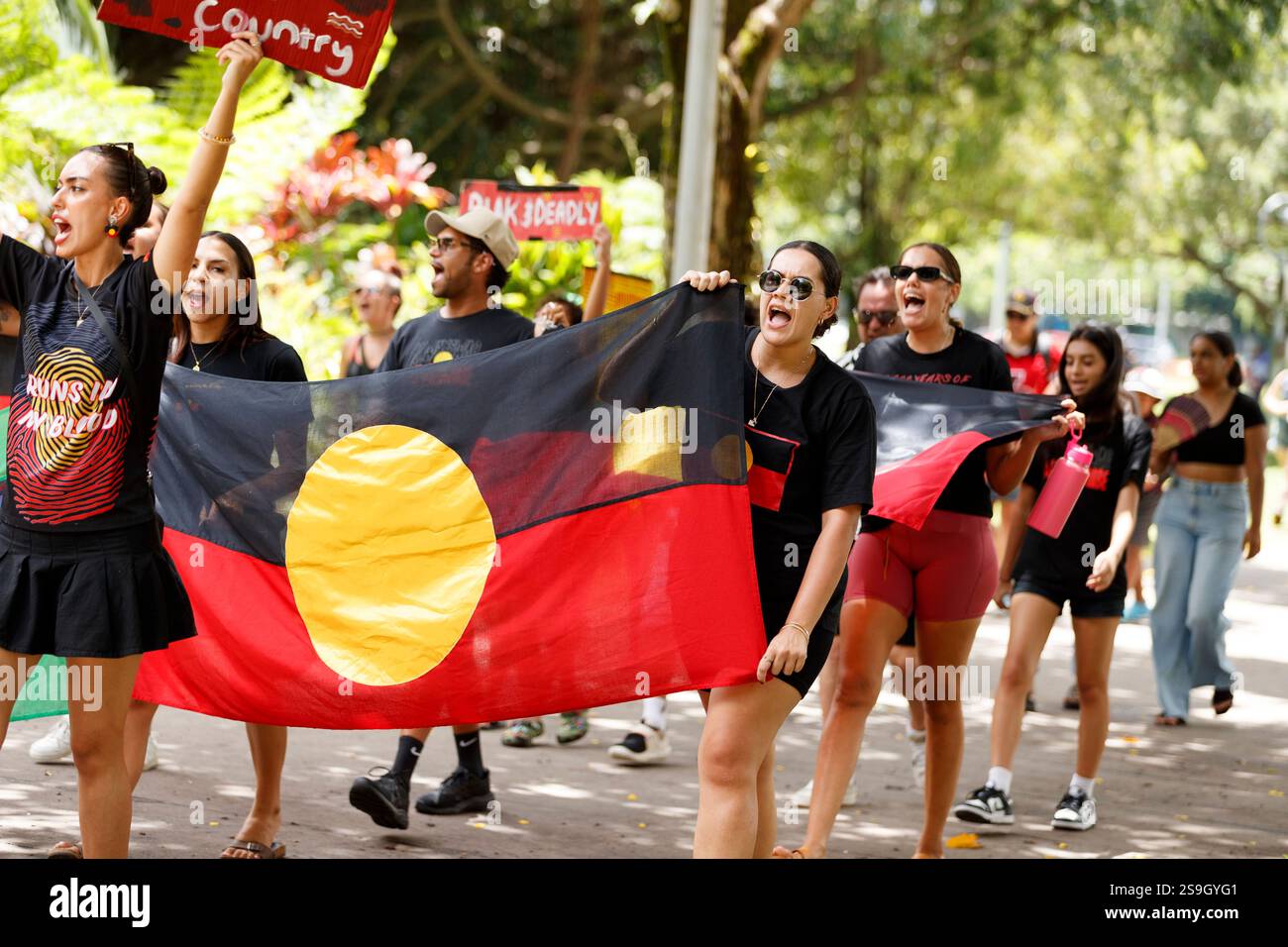 Demonstrators march through the Cairns Esplanade carrying Aboriginal ...