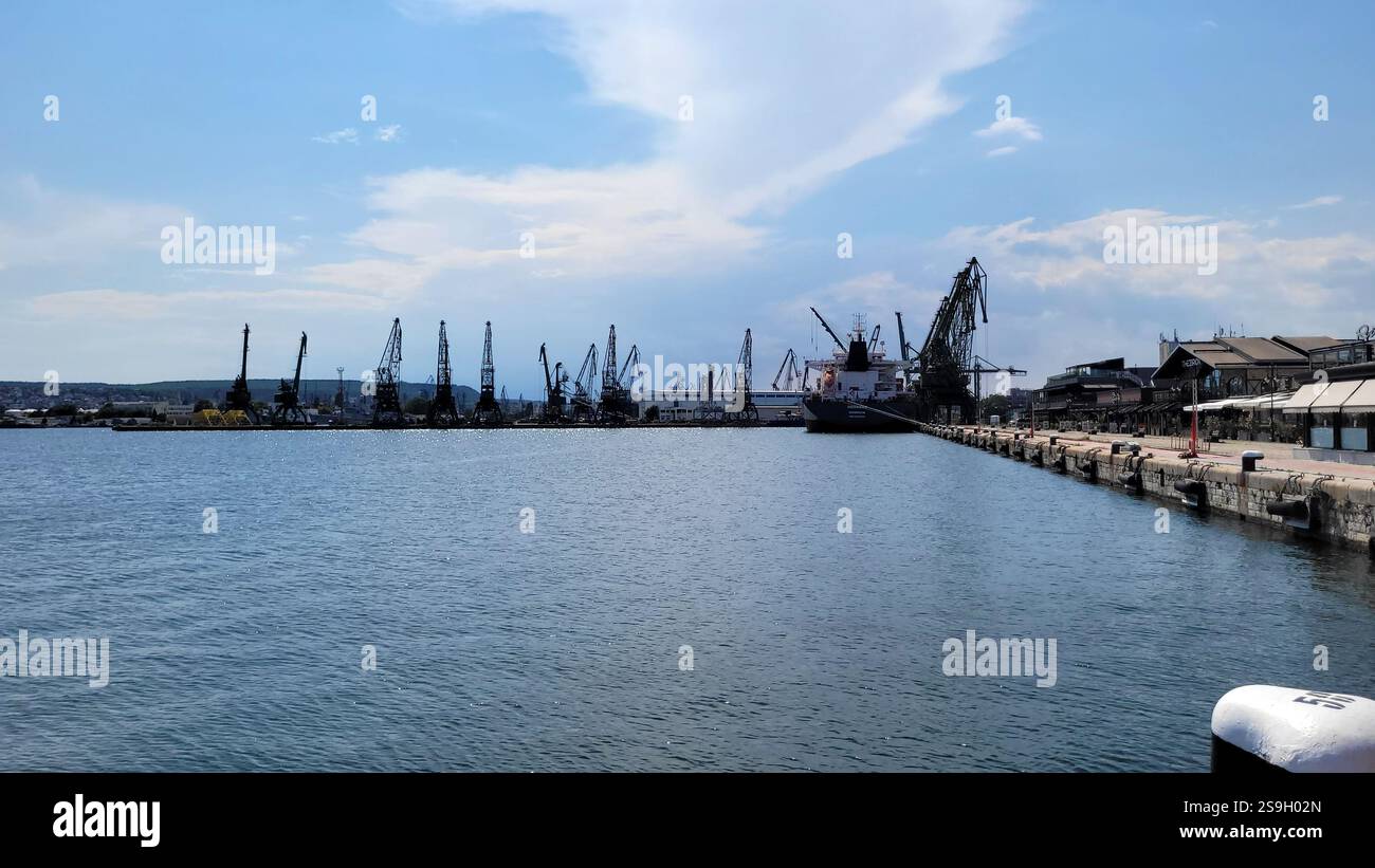 seaport. The focus is on a large cargo ship moored to a pier Stock ...