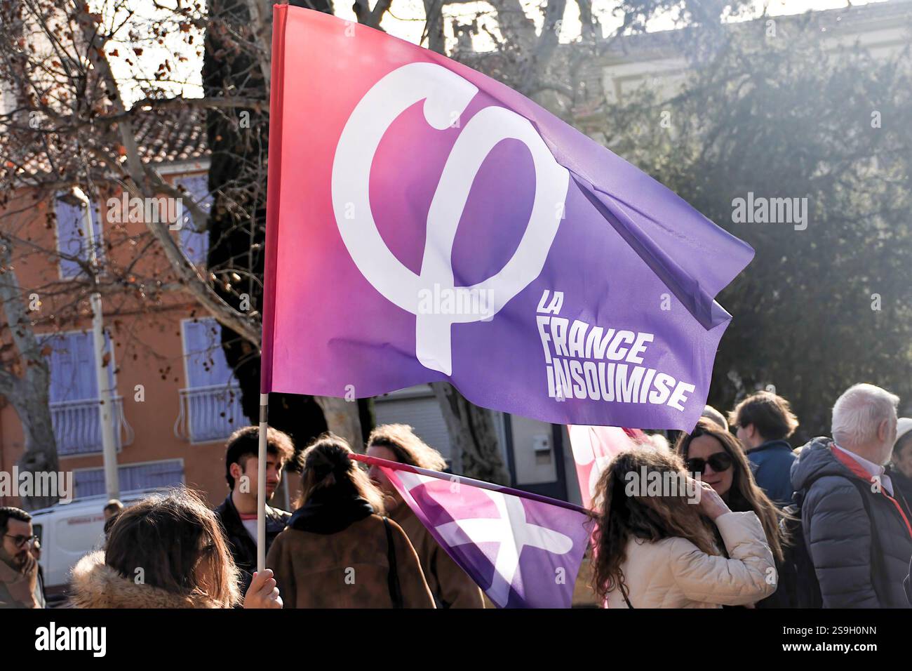 An activist holds a flag of the far-left party La France Insoumise (LFI ...