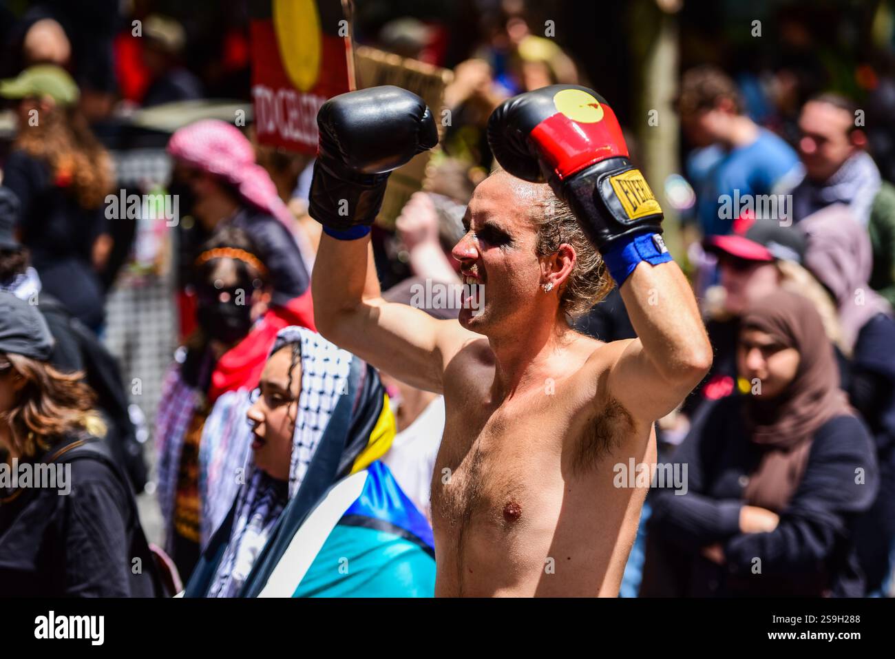 A protester wears boxing gloves in colours of Aboriginal flag during ...