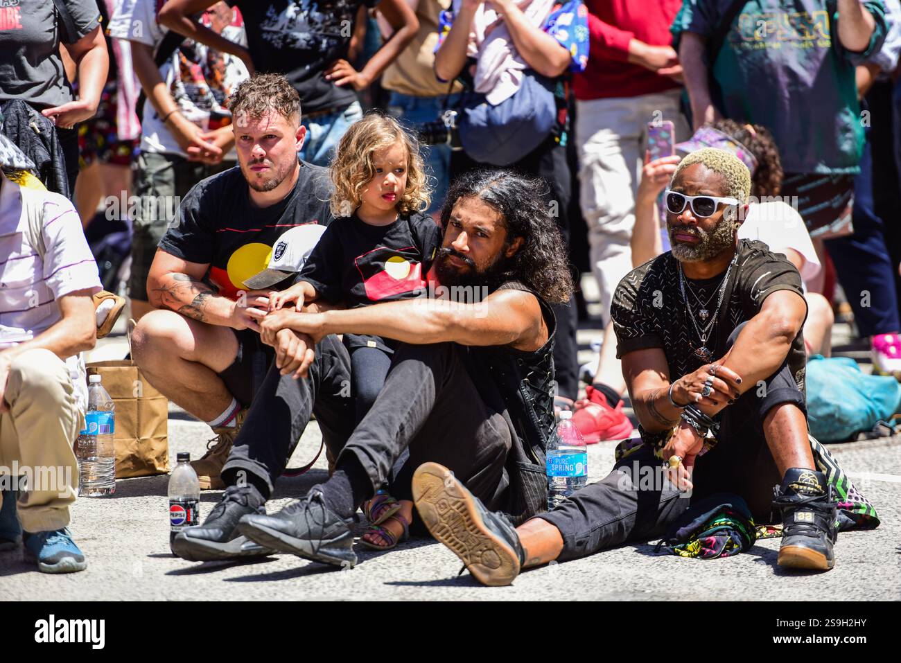 A group of protesters are seen sitting on the pavement of Flinders ...