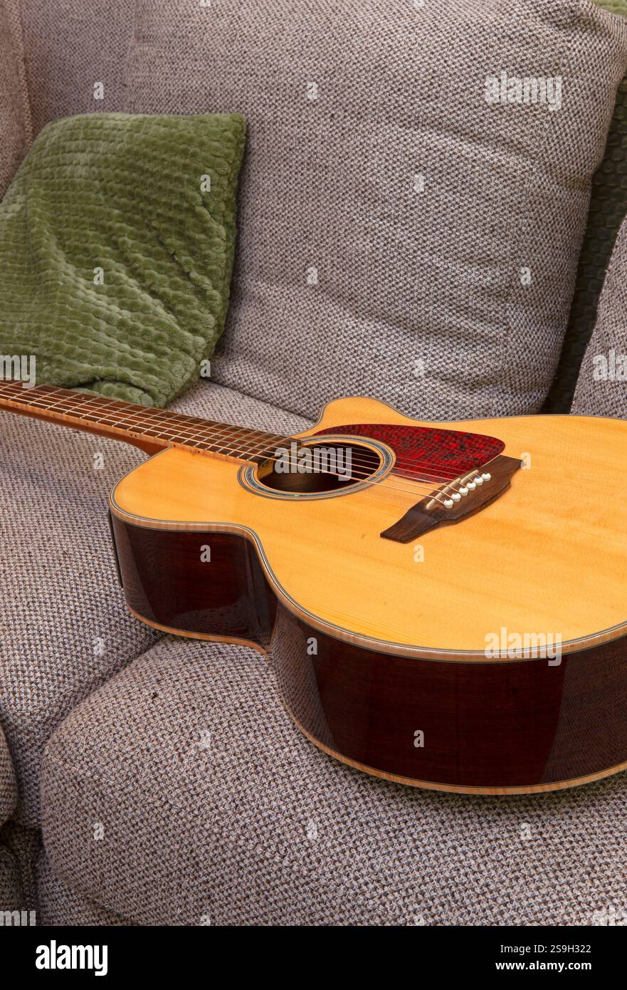 Acoustic guitar on a sofa in a living room. Musical instrument Stock ...