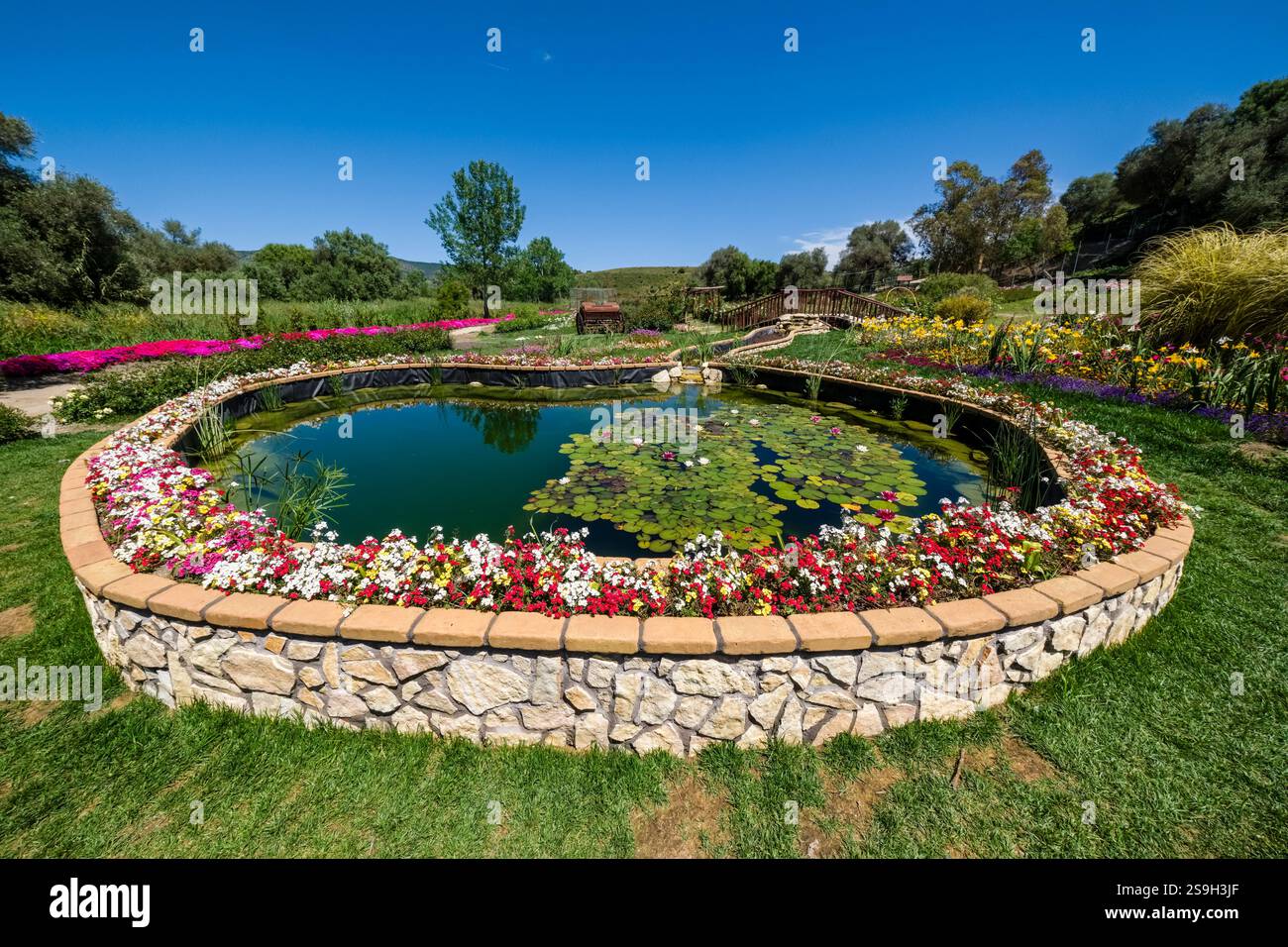Water basin planted with colourful flowers in the Giardino di Turri, a ...
