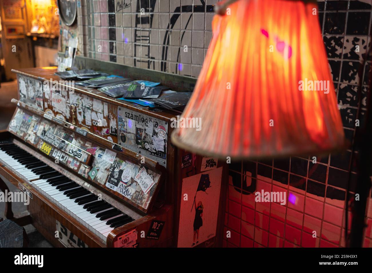 Vintage and Worn-Out Piano Covered in Stickers in a Dimly Lit Room ...