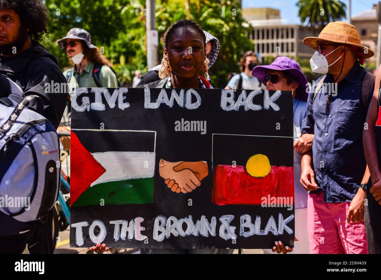 African female protester holds a banner in support of Indigenous ...