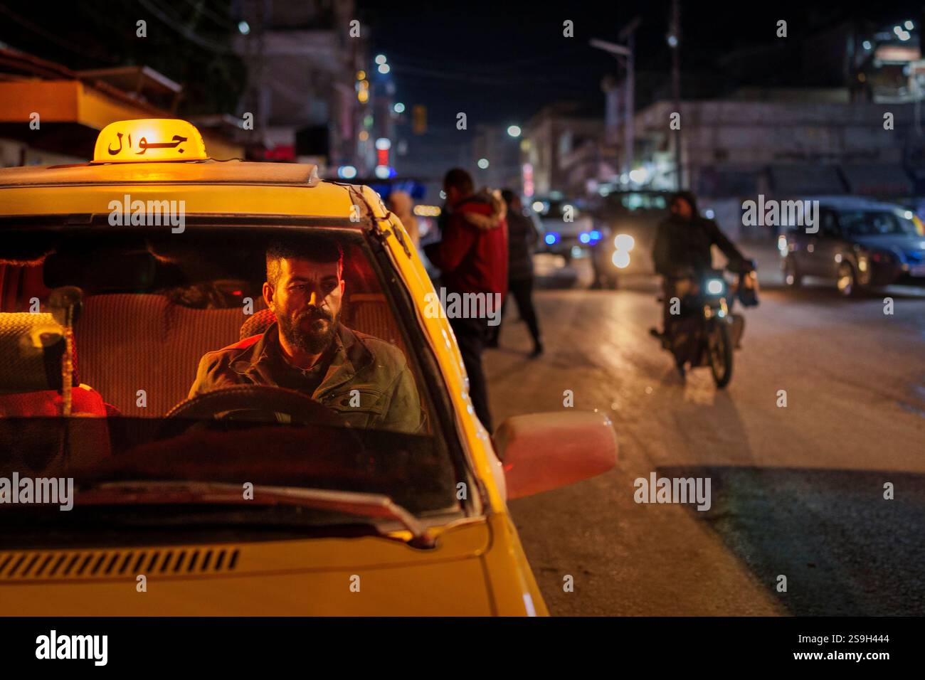 A taxi driver waits for customers in the northern Syrian city of ...