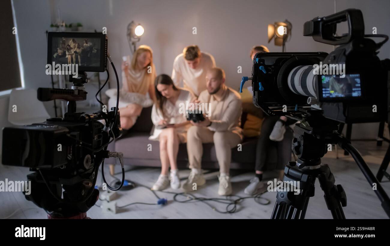 Backstage studio. Team communicate. Group people compares shooting results with planned project ...