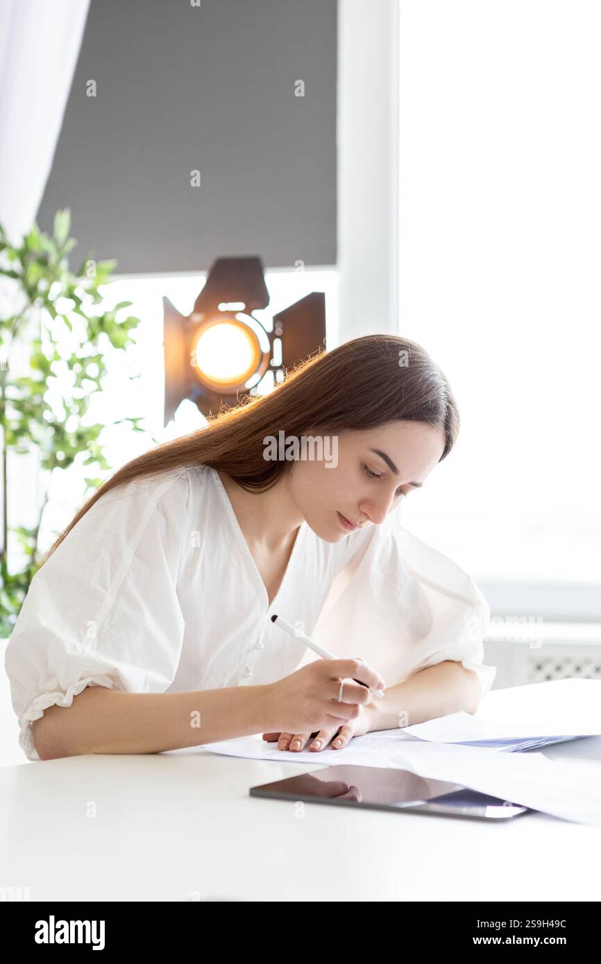 Write studio. Woman handwriting. Girl makes notes paper in room ...