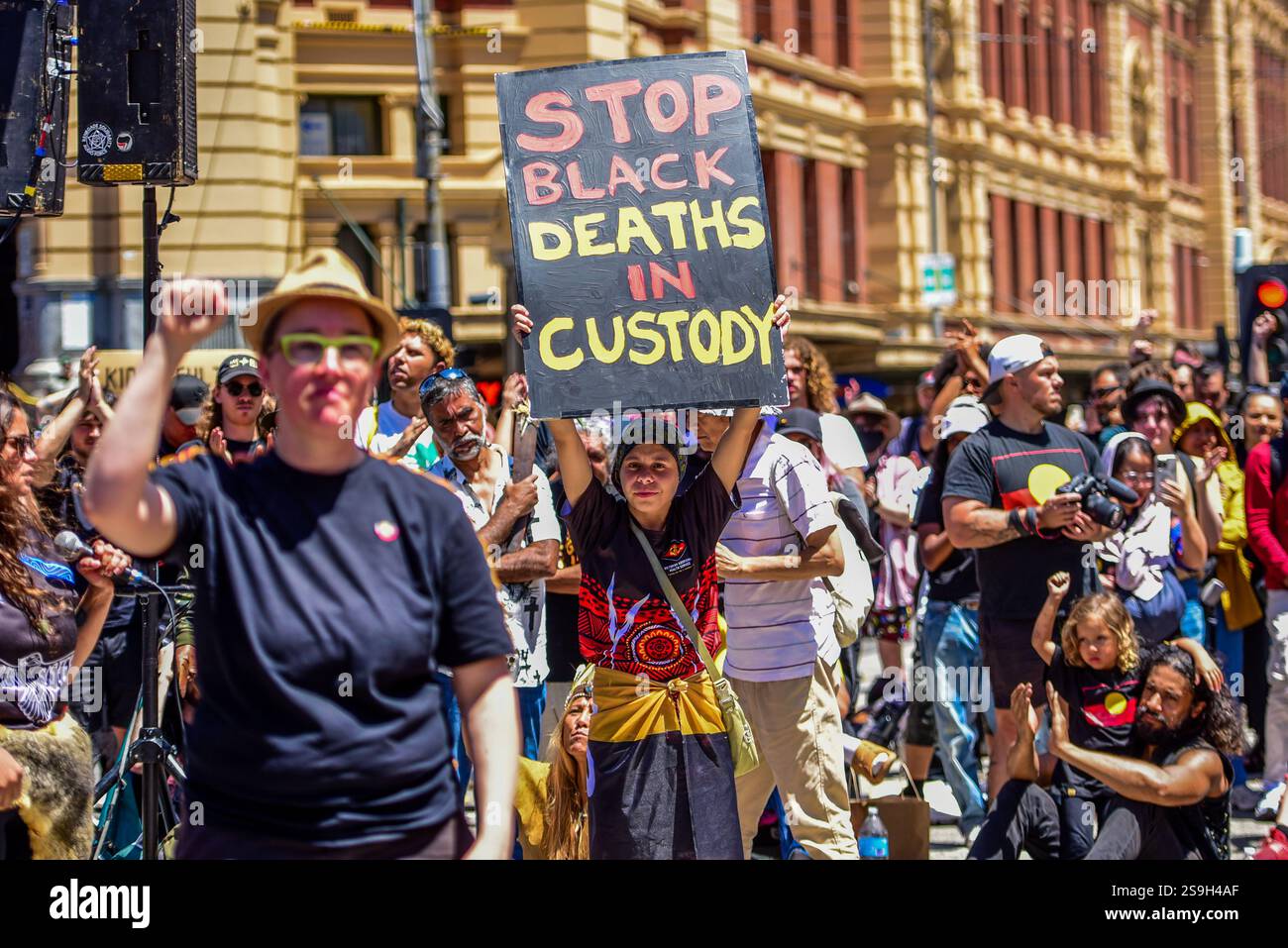 A protester holds a placard reading "Stop black deaths in custody" in ...