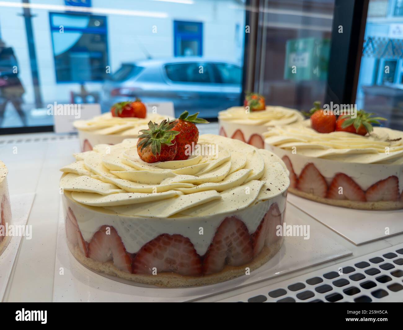 Delicious strawberry cakes adorned with cream in a bakery display ...