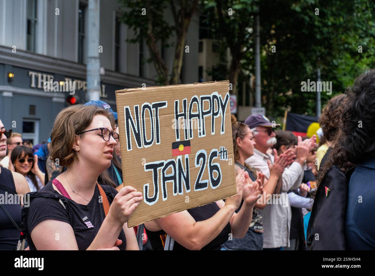 A protester with a banner against Australia Day celebration is seen ...